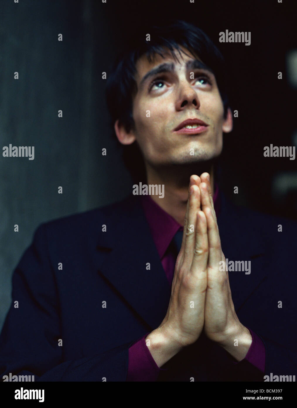 Man in suit praying, looking up Stock Photo - Alamy