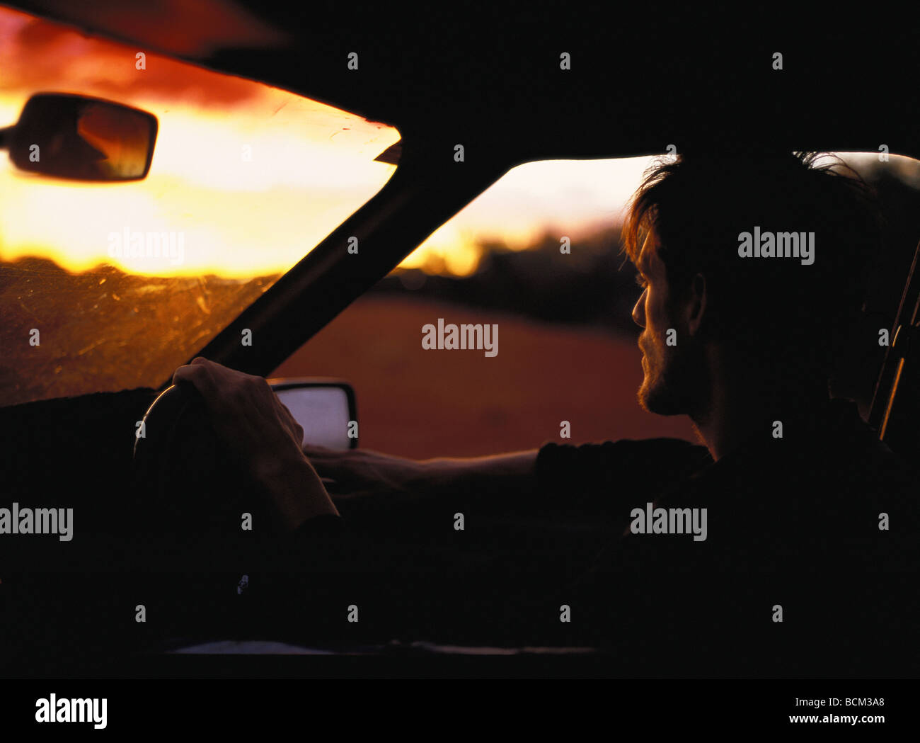 Man driving car at sunset, interior view Stock Photo - Alamy