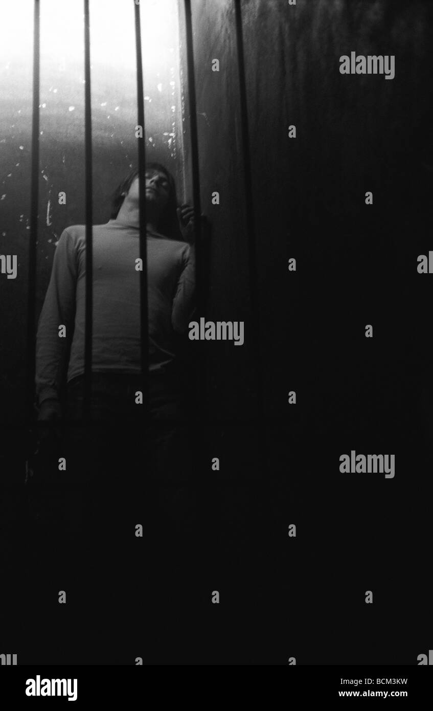 Man standing behind bars Stock Photo - Alamy