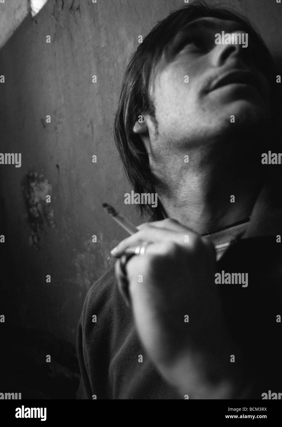 Man smoking cigarette, looking up Stock Photo - Alamy