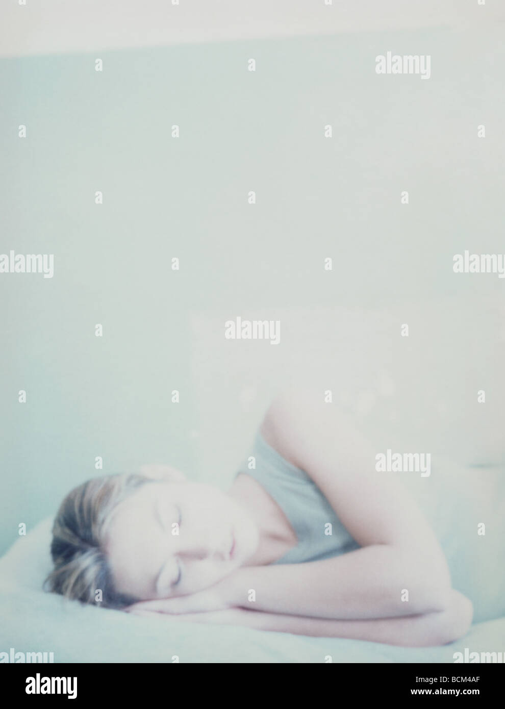 Young woman sleeping on side, hands under head, overexposure Stock ...