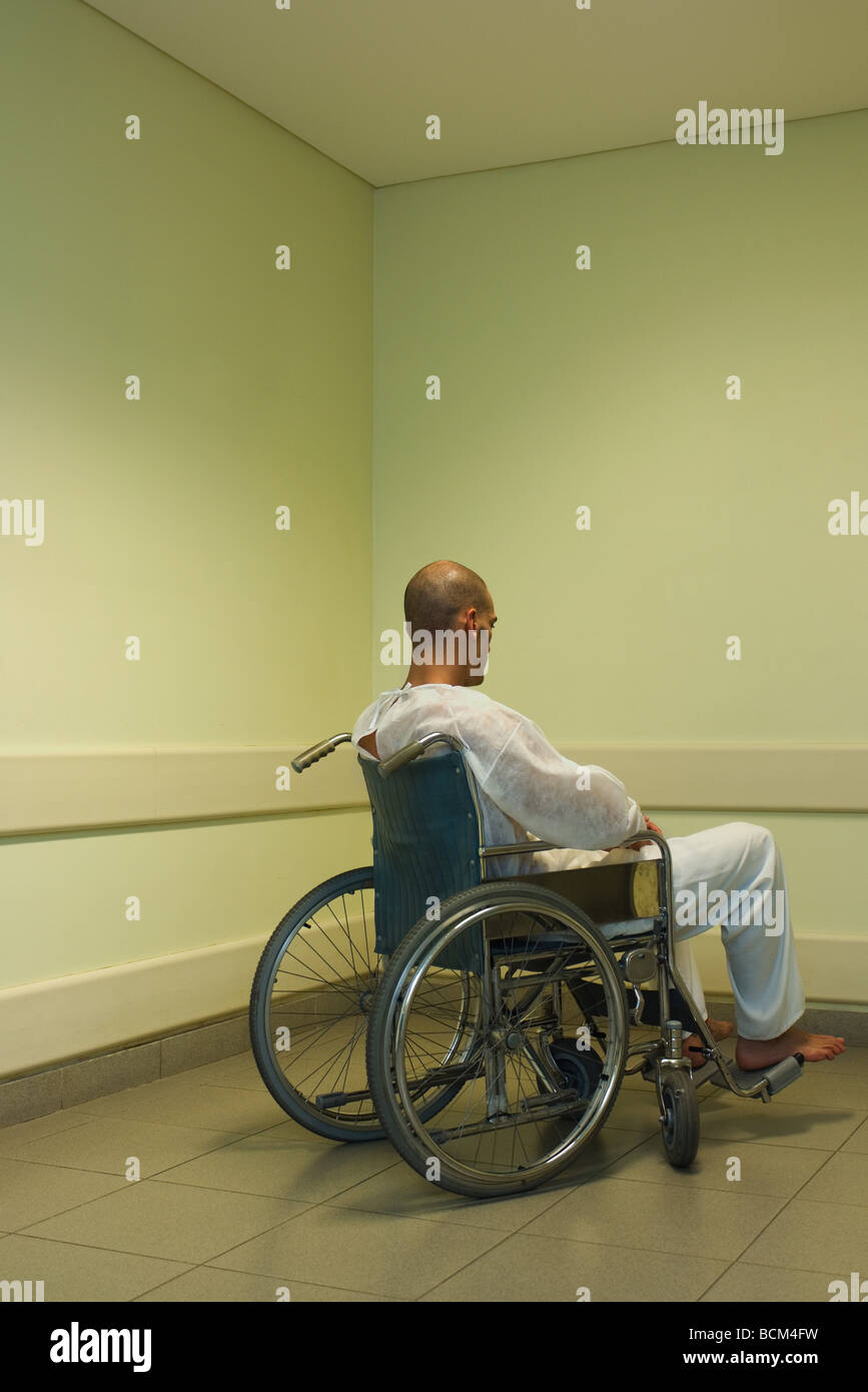 Man sitting in wheelchair in corner, facing wall Stock Photo - Alamy