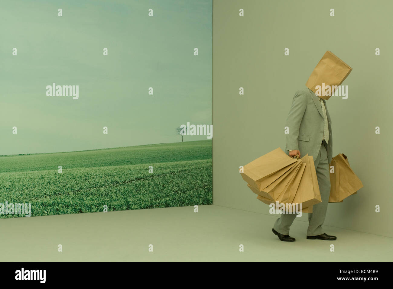 Man wearing paper bag over head, carrying several shopping bags, rural ...