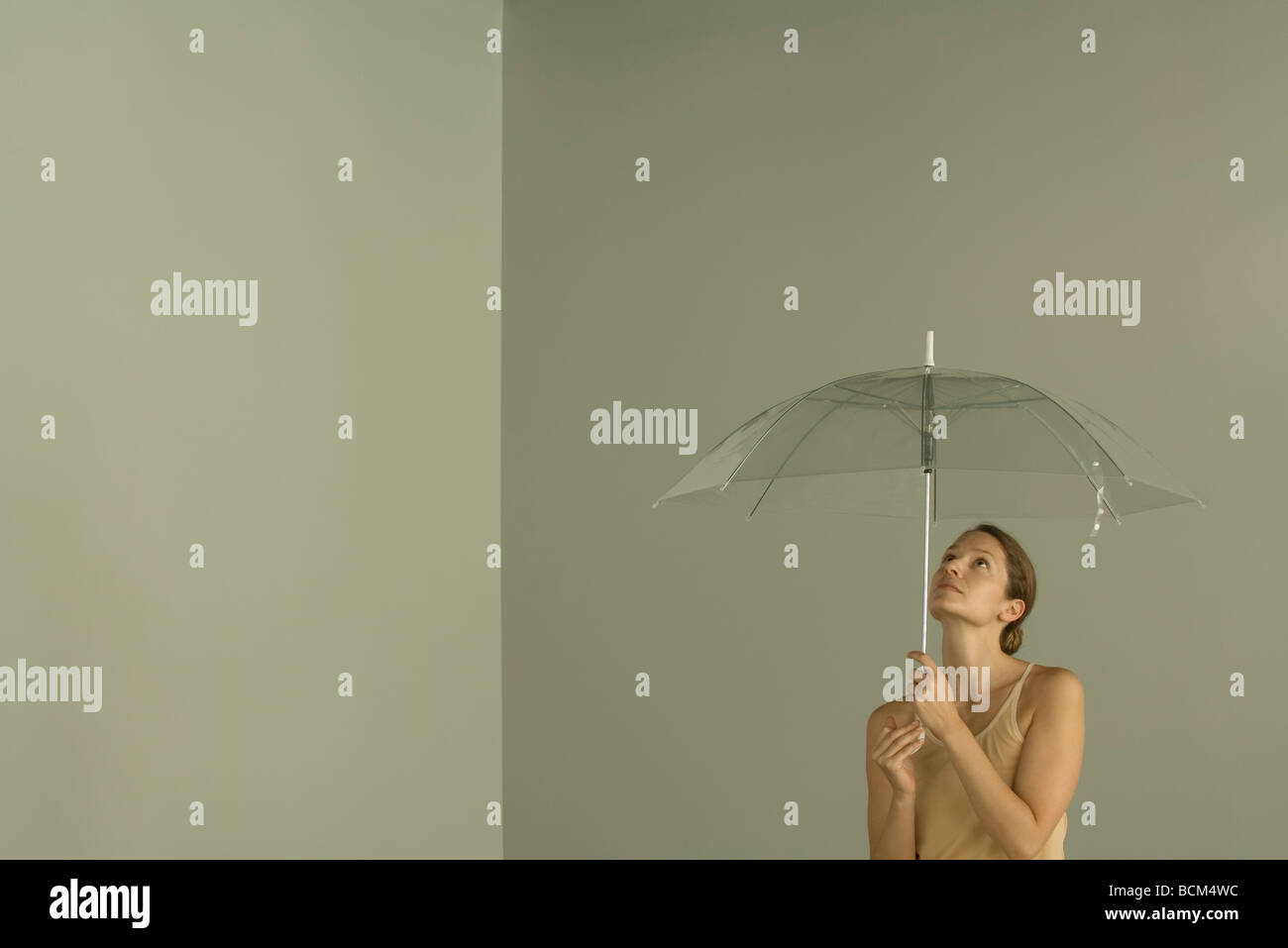 Woman underneath umbrella indoors Stock Photo - Alamy