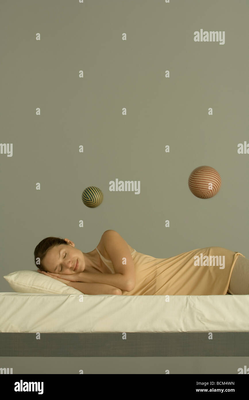 Woman sleeping in bed, two spheres floating in the air above her Stock ...