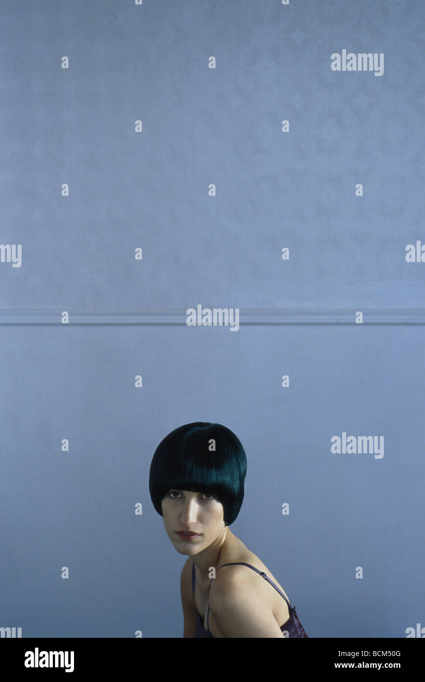 Woman looking over shoulder at camera, portrait Stock Photo - Alamy