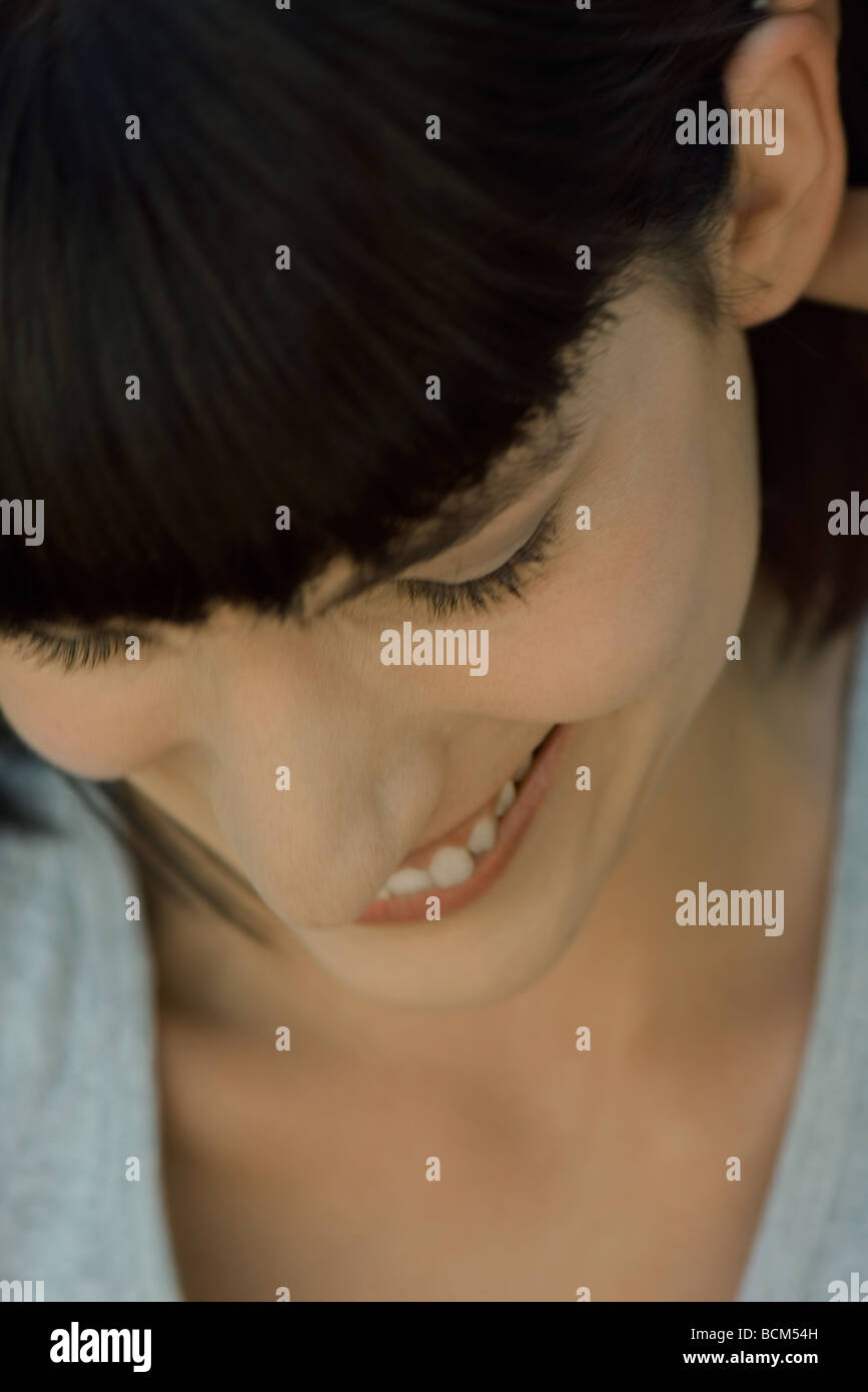 Young woman looking down, smiling Stock Photo - Alamy