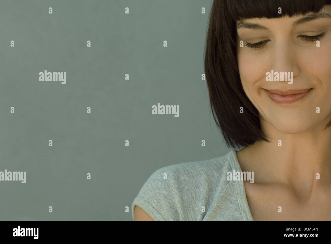 Woman with eyes lowered, smiling Stock Photo - Alamy