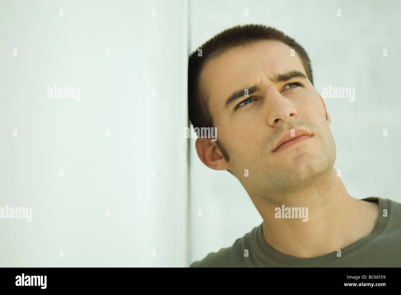 Man leaning head against wall, looking up Stock Photo - Alamy