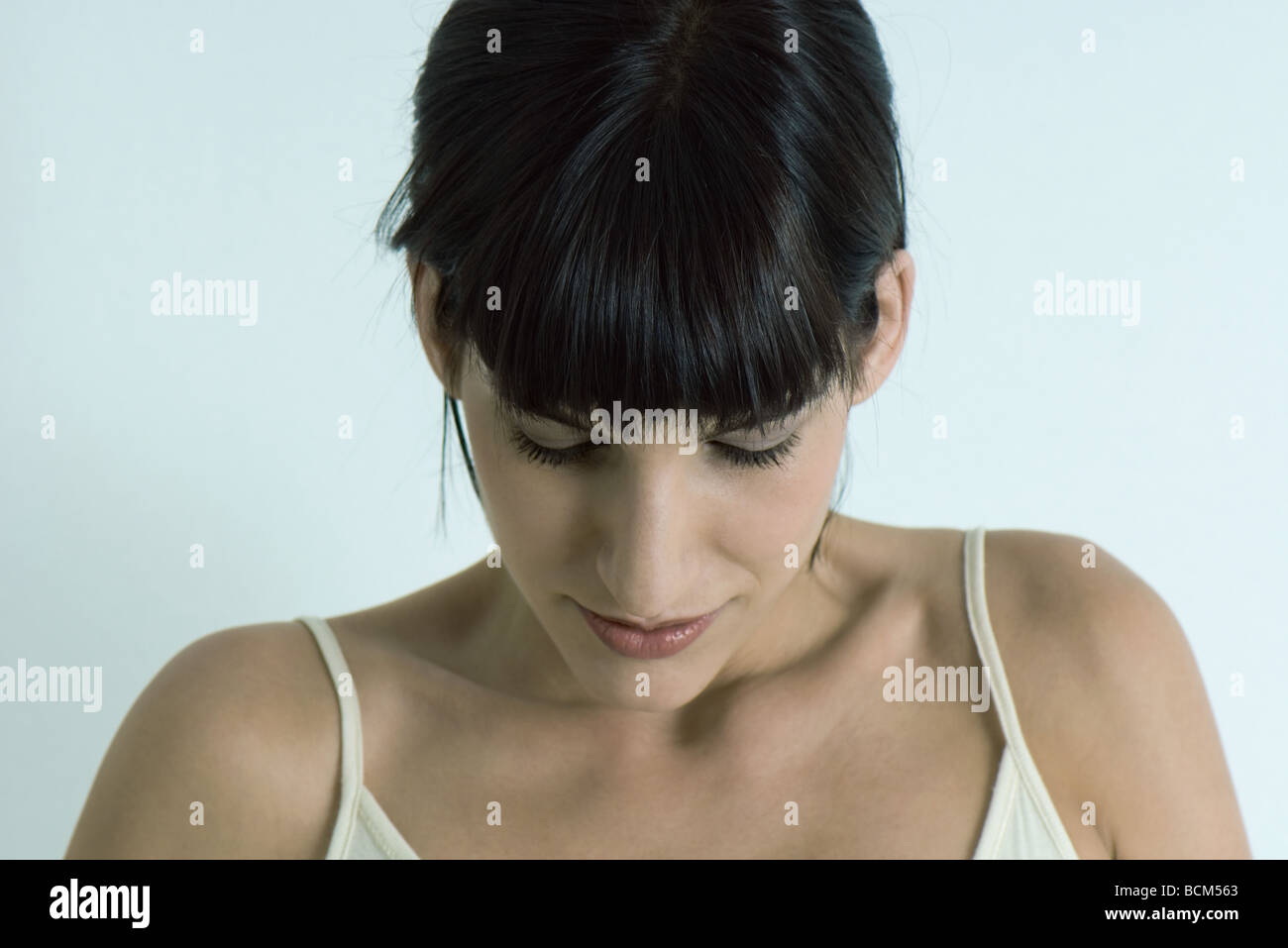 Young woman with head down, looking down Stock Photo - Alamy