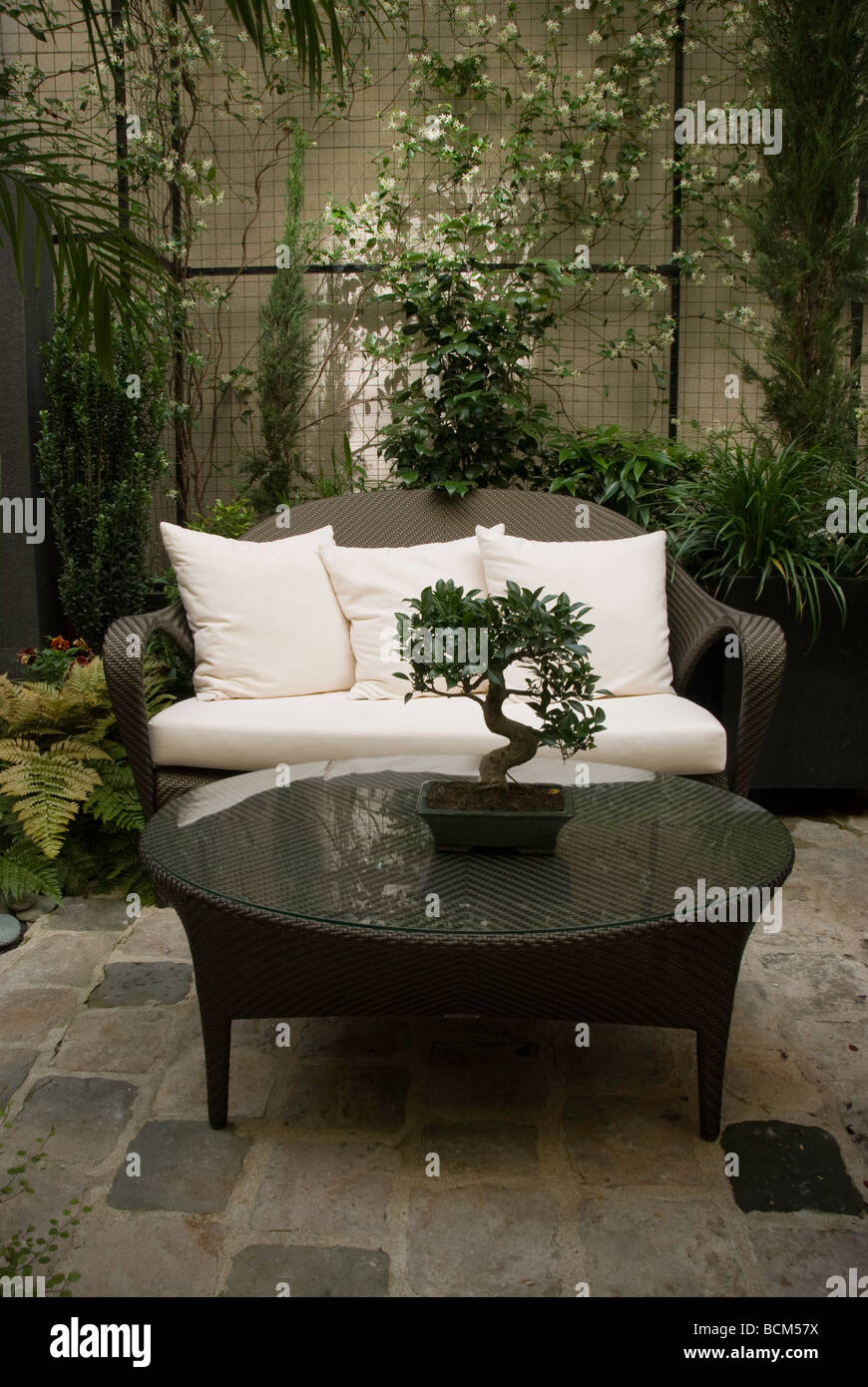 Modern, outdoor couch and table set in a tranquil courtyard garden ...