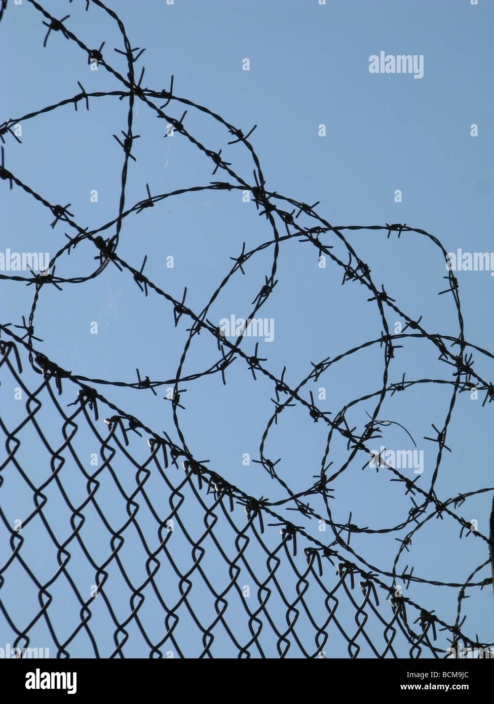 dark high wall fence with barbed wire outdoors Stock Photo - Alamy