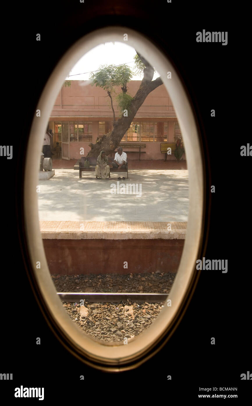 Looking through the oval window of a luxury train in India. An elderly ...