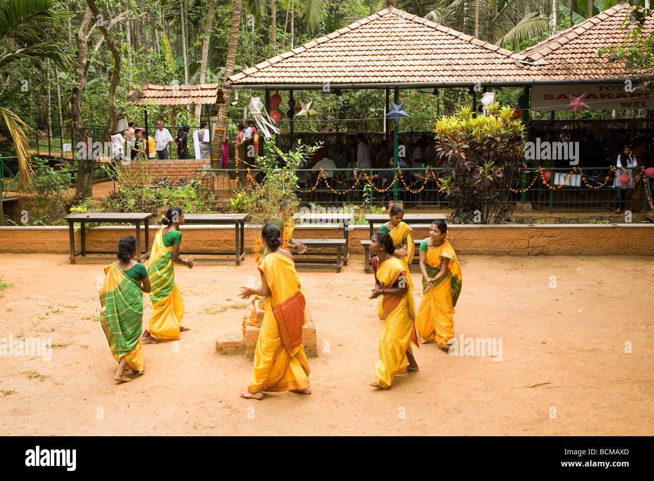 A group of Indian women in silk sarees perform a traditional dance in ...
