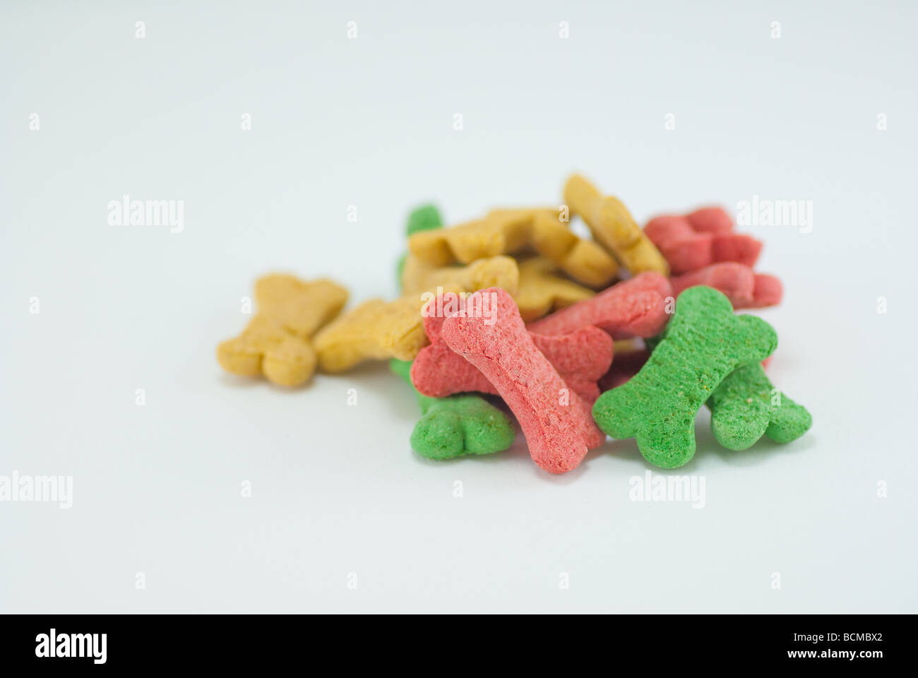 a pile of colorful dog bones, red green and yellow all isolated on ...