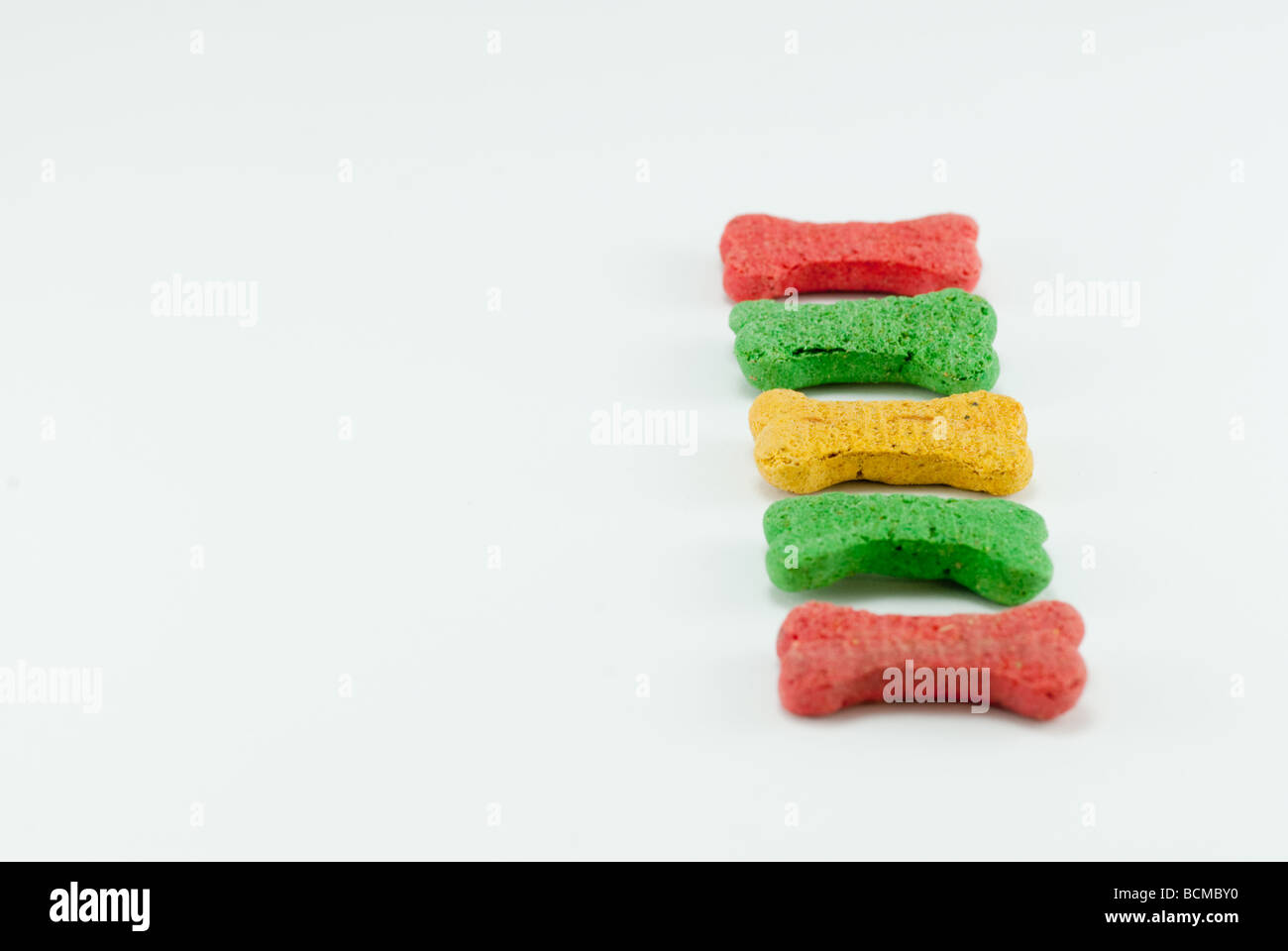 five colorful dog bones, red green and yellow all isolated on white ...