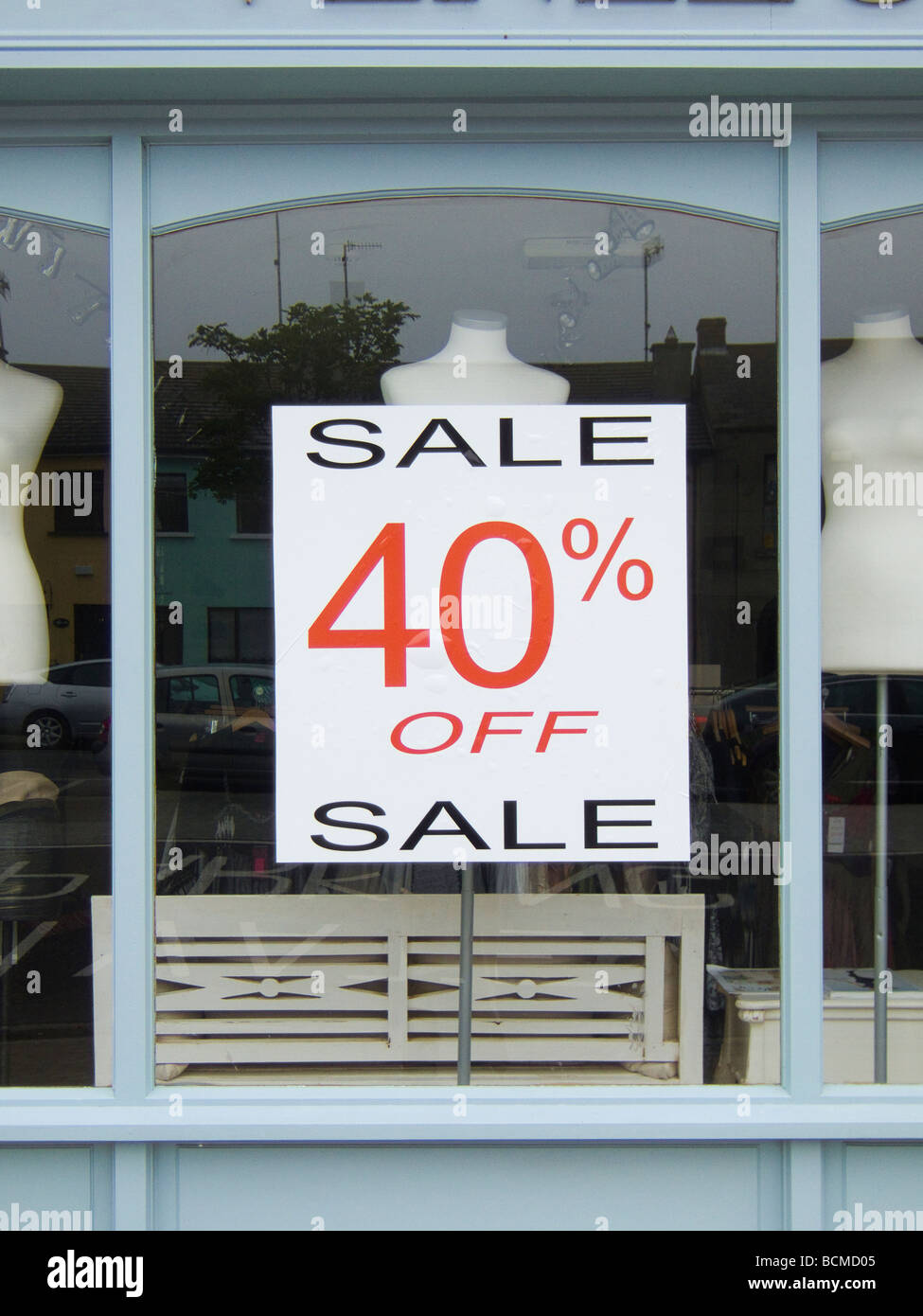 A sign in a clothing shop window offering massive discounts due to the ...