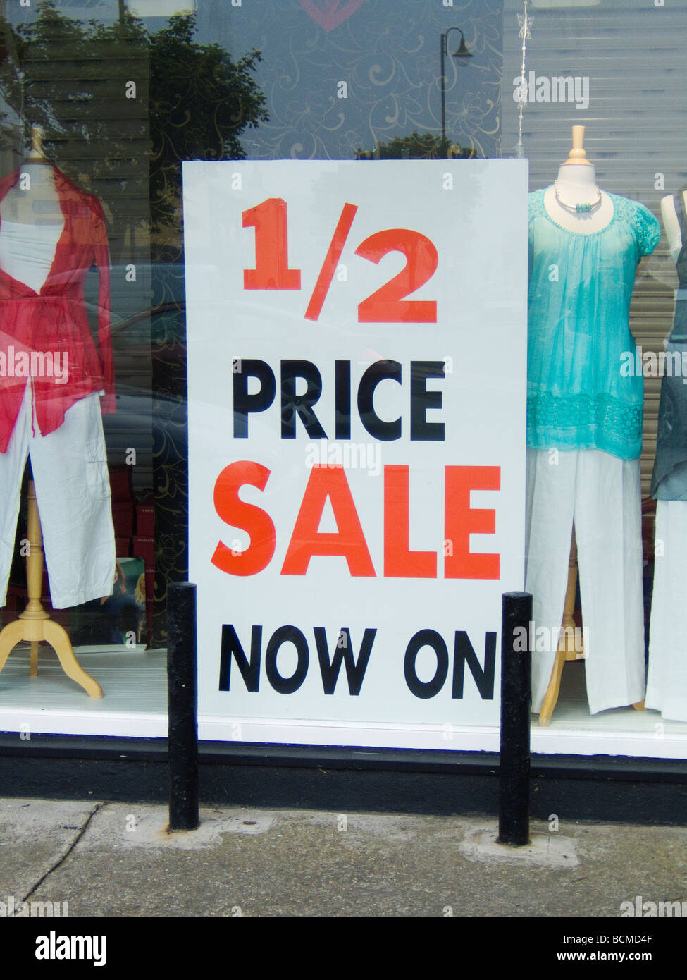 A sign in a clothing shop window offering massive discounts due to the ...
