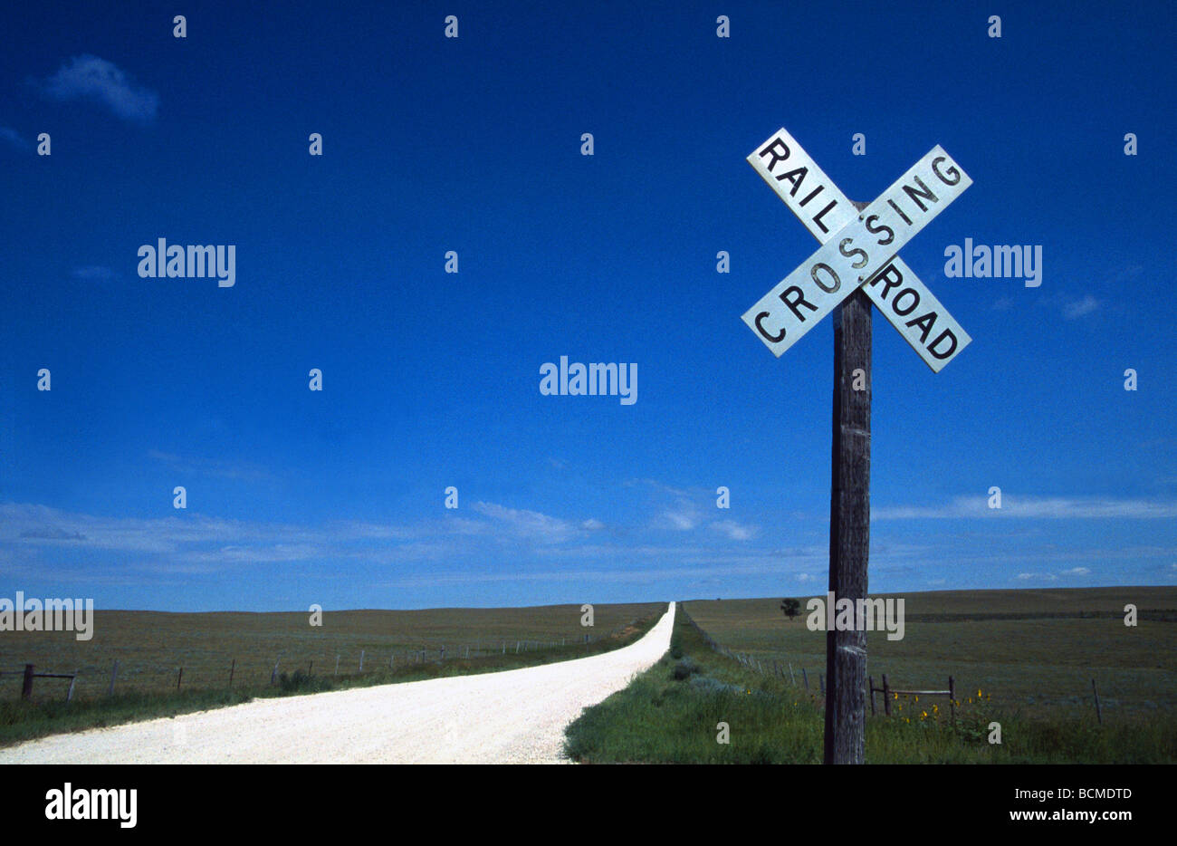 Long empty road and railroad crossing sign in the Great Plains Nebraska ...
