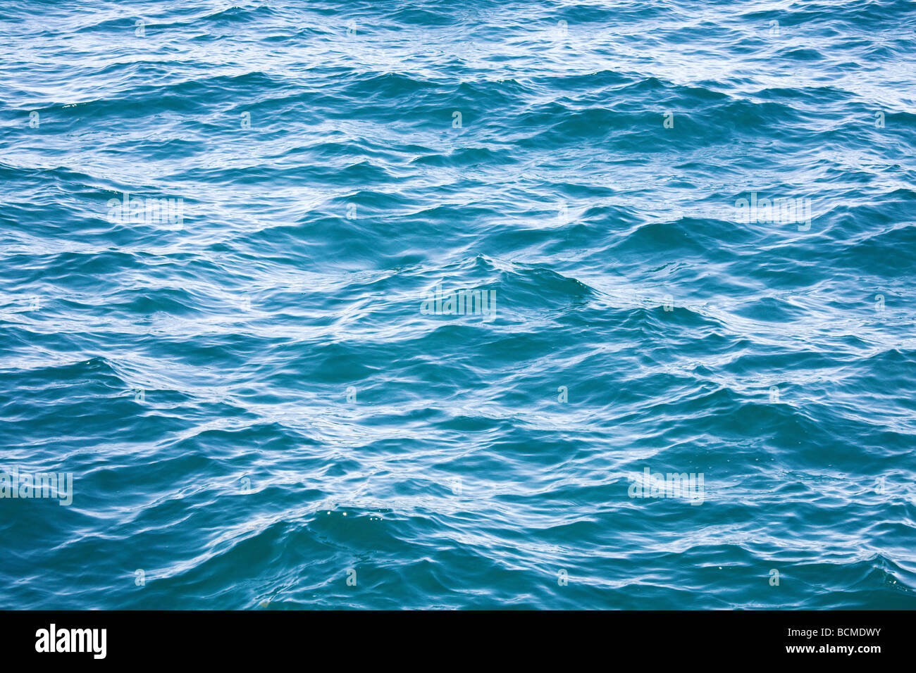 Azure sea water surface with ripple and cloud reflections Stock Photo ...
