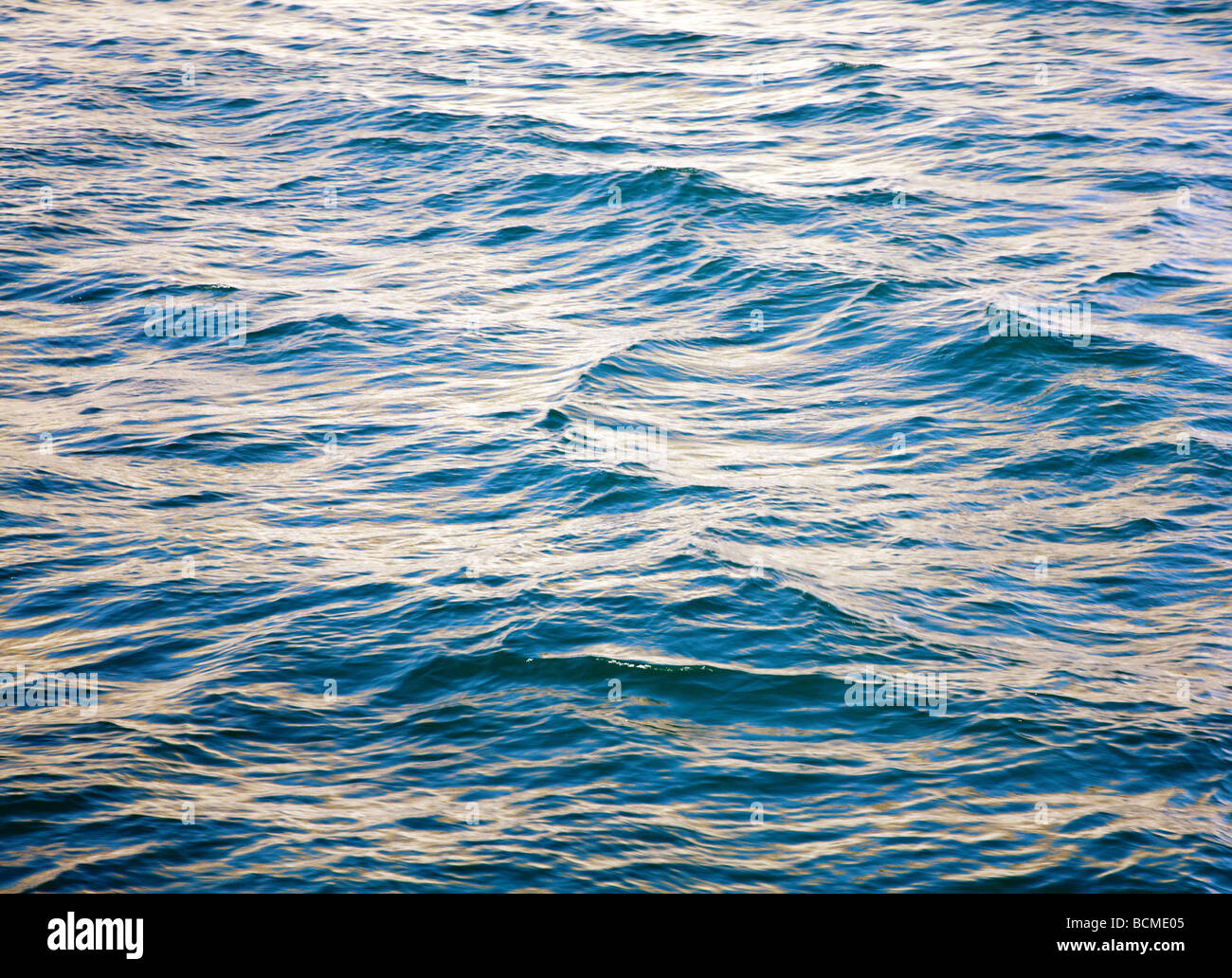 Azure sea water surface with ripple and cloud reflections Stock Photo ...