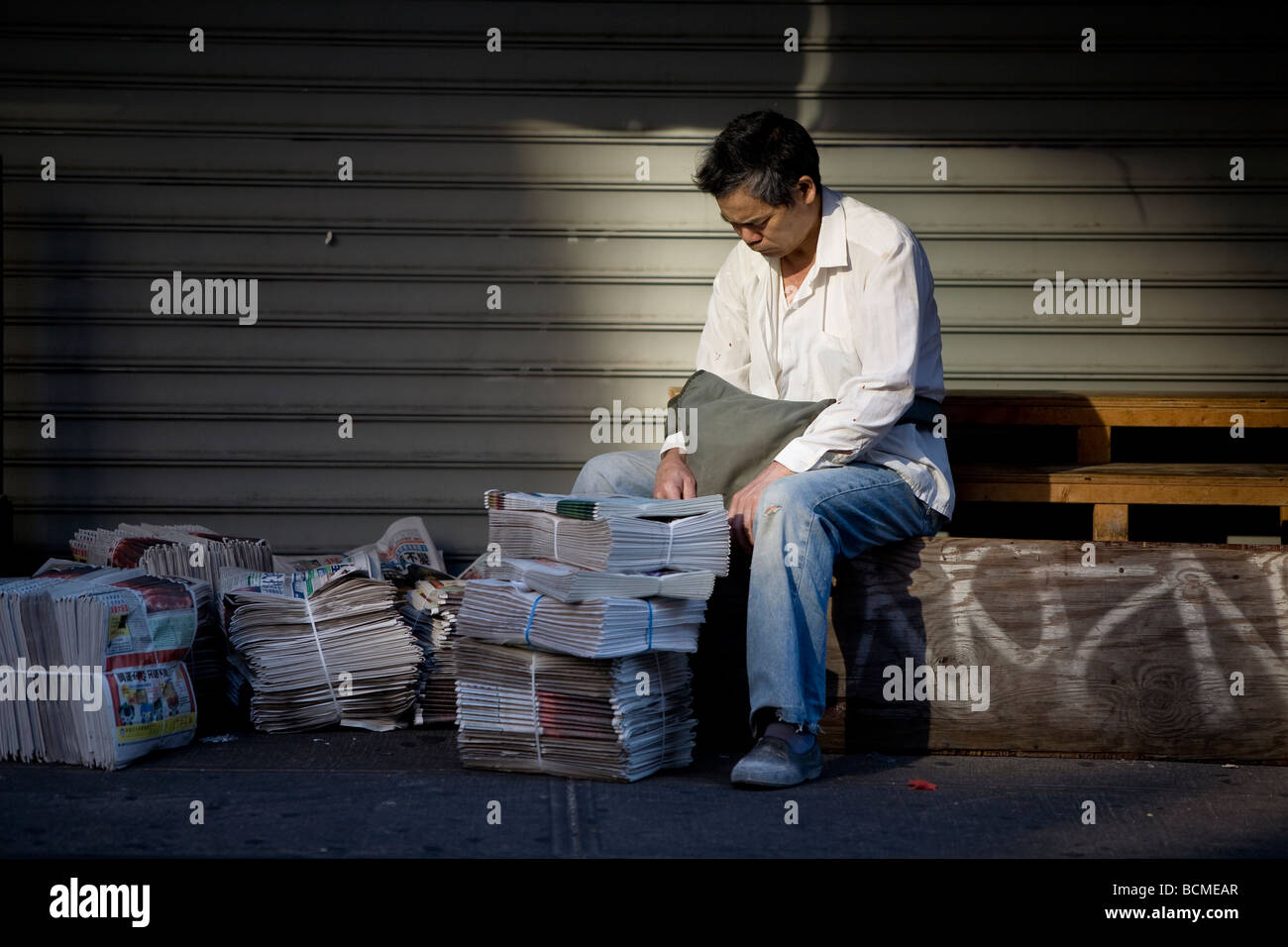 Man reading newspaper while waiting for his employer to pick him up for ...