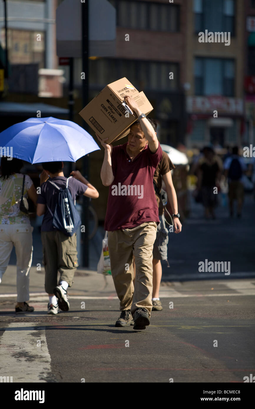 Man carring package across the street, Chinatown, Manhattan, NY, USA ...