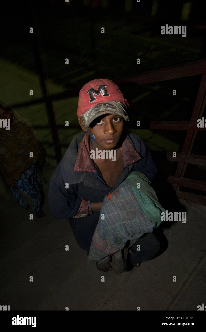 Homeless child at night in red cap at Khulna railway station Bangladesh ...