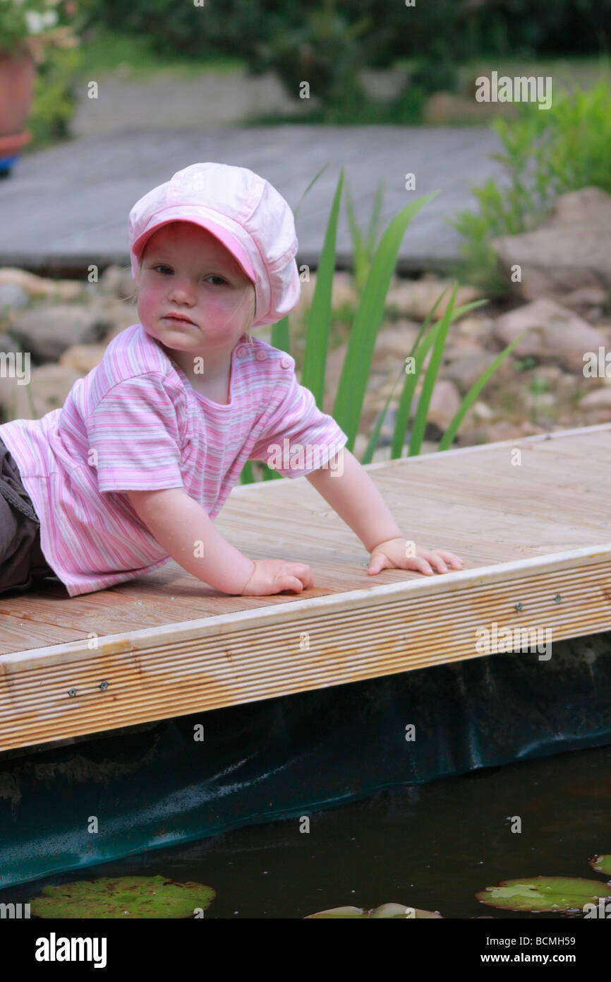 cute little girl playing at the garden pond Stock Photo - Alamy