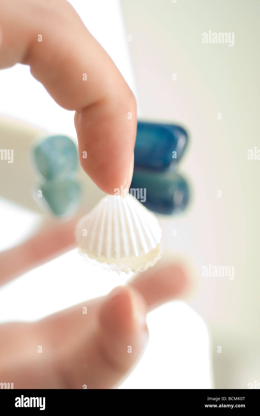 woman hand and fingers touching a shell - blue stones backgound Stock ...