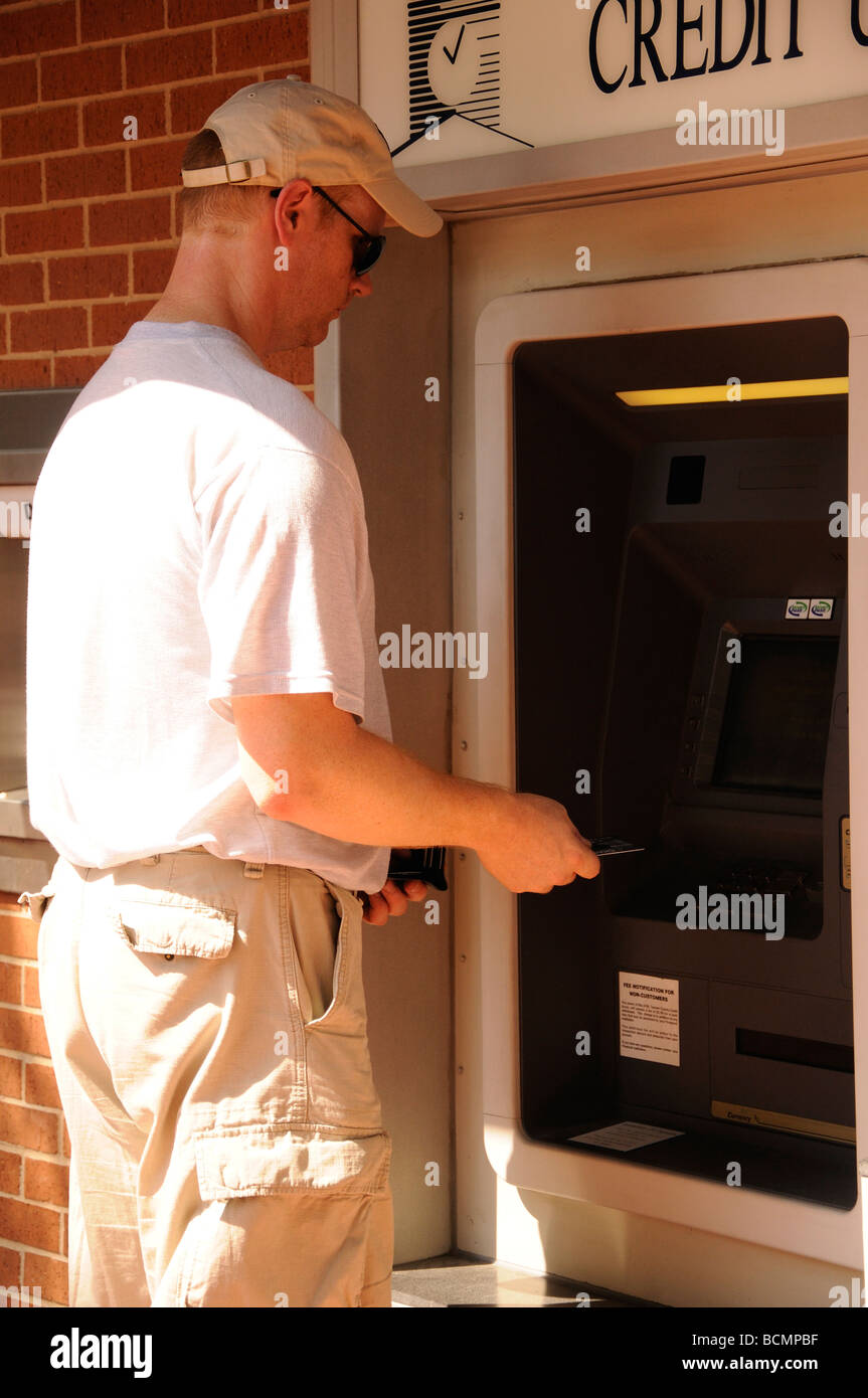 Man using his card at ATM machine Stock Photo - Alamy