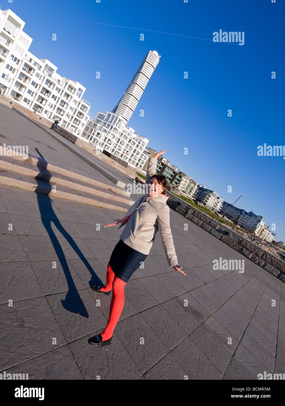 A happy young woman in front of the Turning Torso at the Vastra Hamnen ...