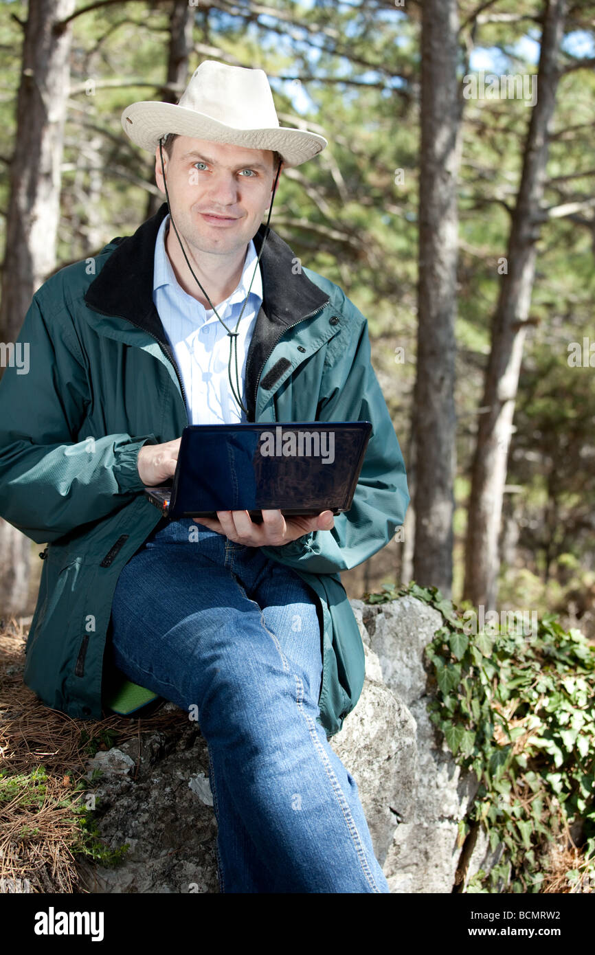 Man with laptop in the forest Stock Photo - Alamy