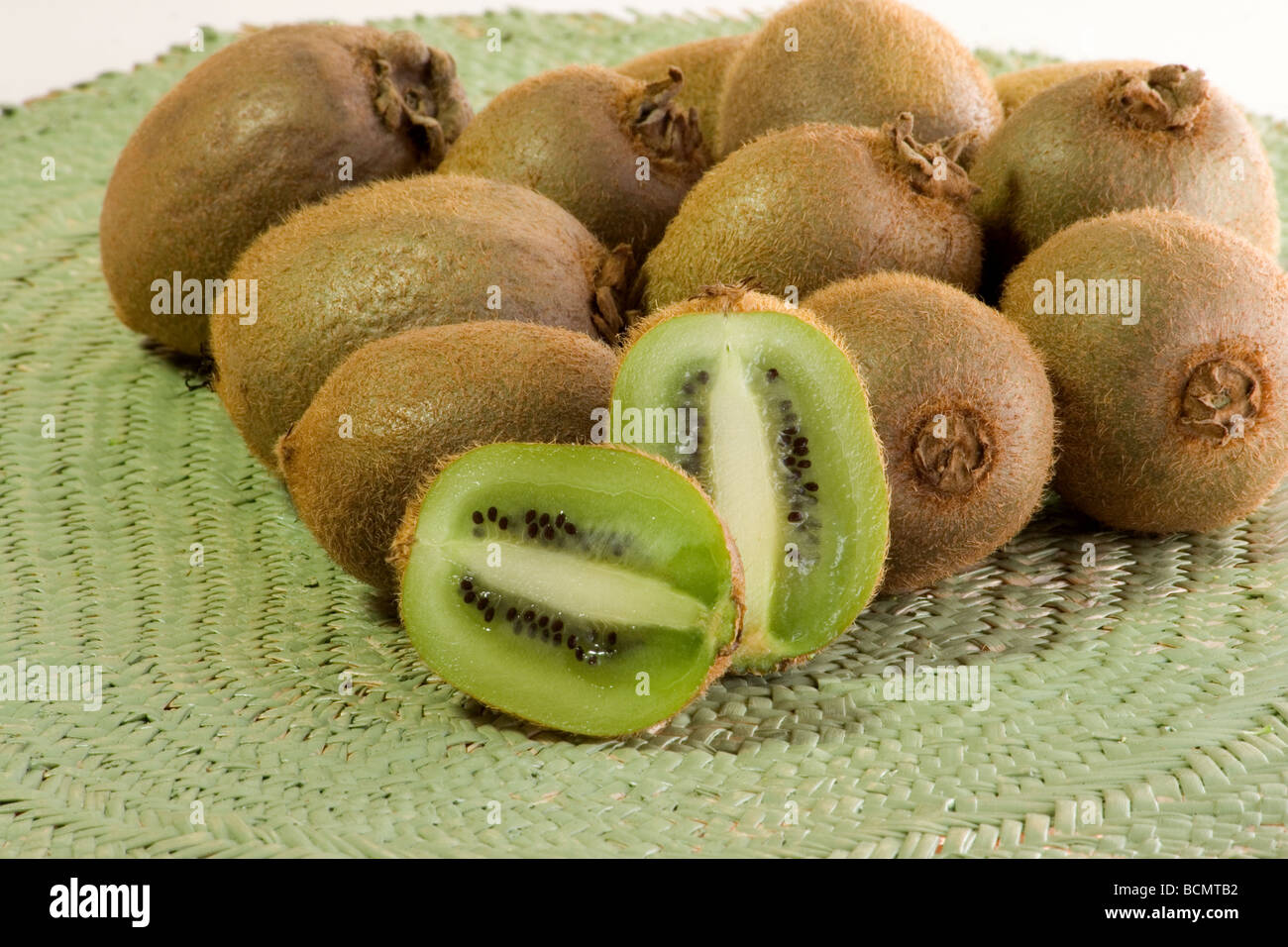 Close-up of kiwi fruits on wicker mat isolated on white Stock Photo - Alamy