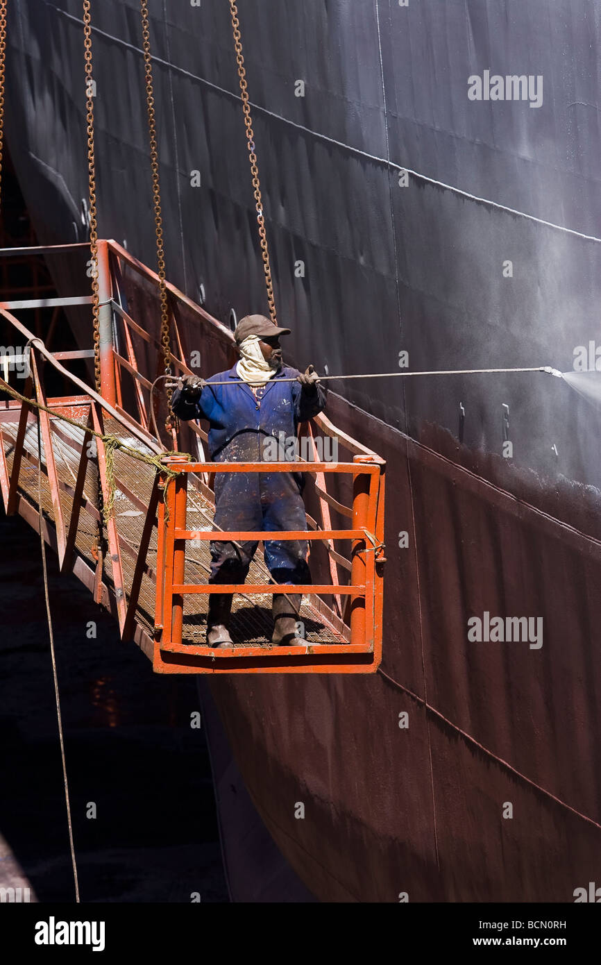 Man cleans the hull of a ship in dry dock, Cape Town, South Africa ...