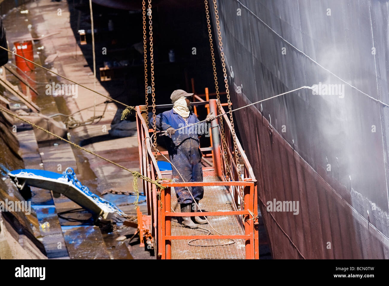 Man cleans the hull of a ship in dry dock, Cape Town, South Africa ...