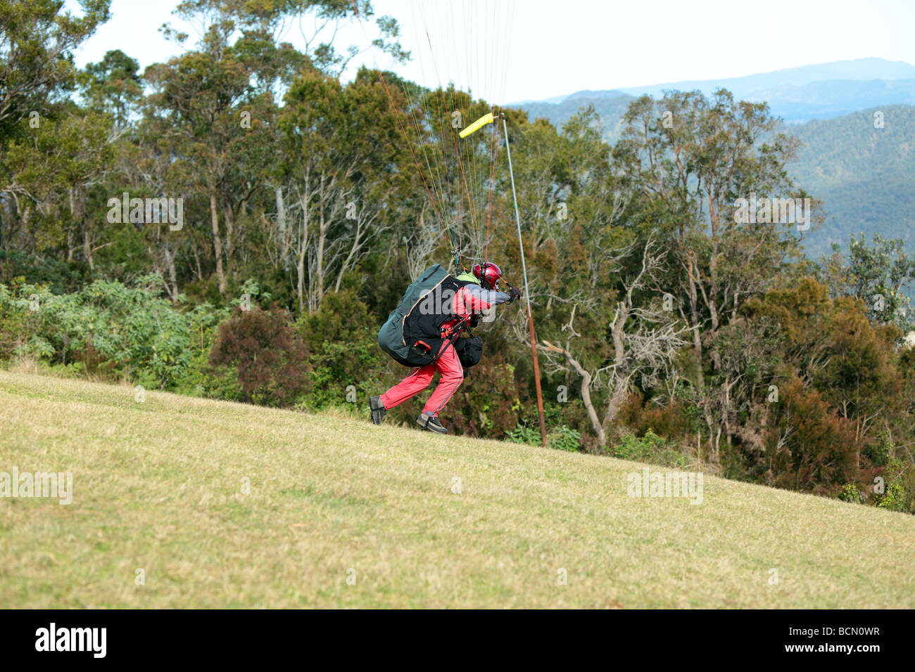 Paragliding with canopy fully inflated and pilot navigating to landing ...