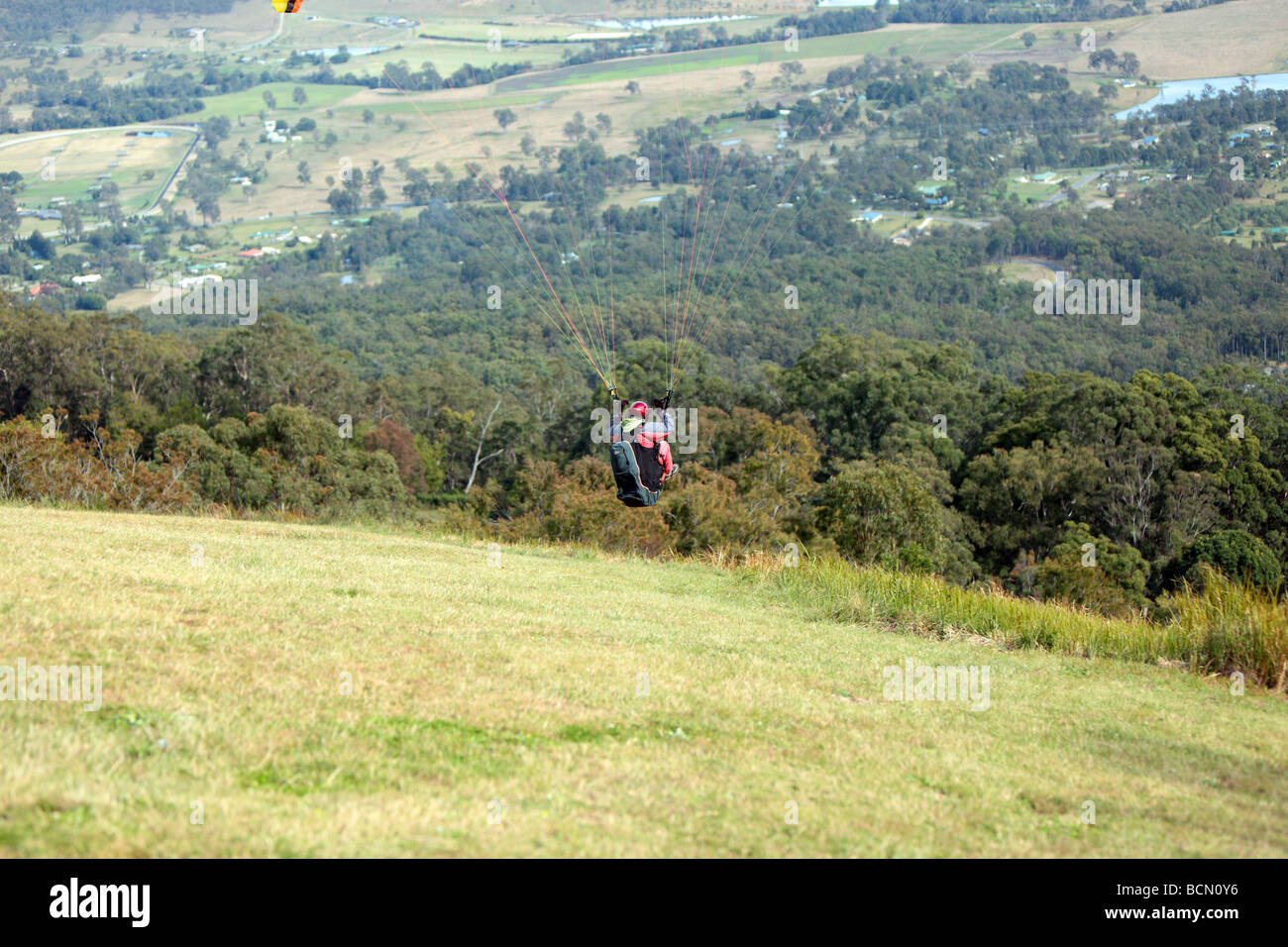 Paragliding with canopy fully inflated and pilot navigating to landing ...
