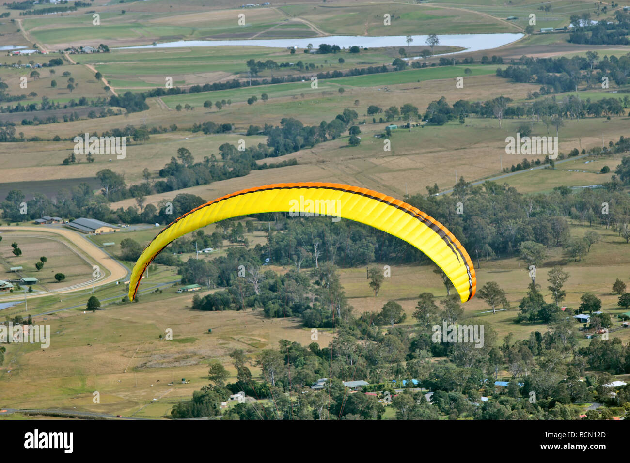Paragliding with canopy fully inflated and pilot navigating to landing ...