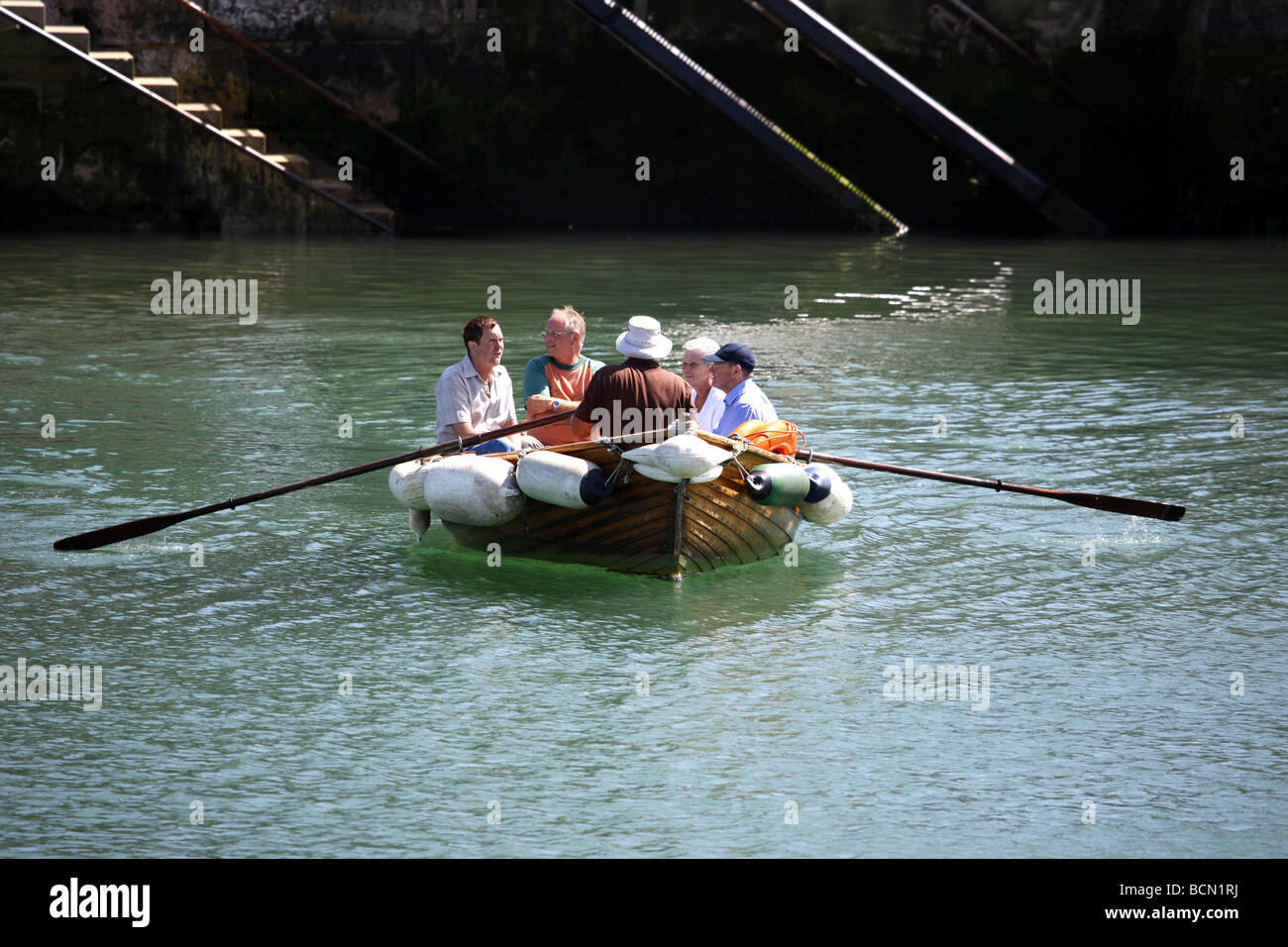 Five people in a rowing boat Stock Photo - Alamy