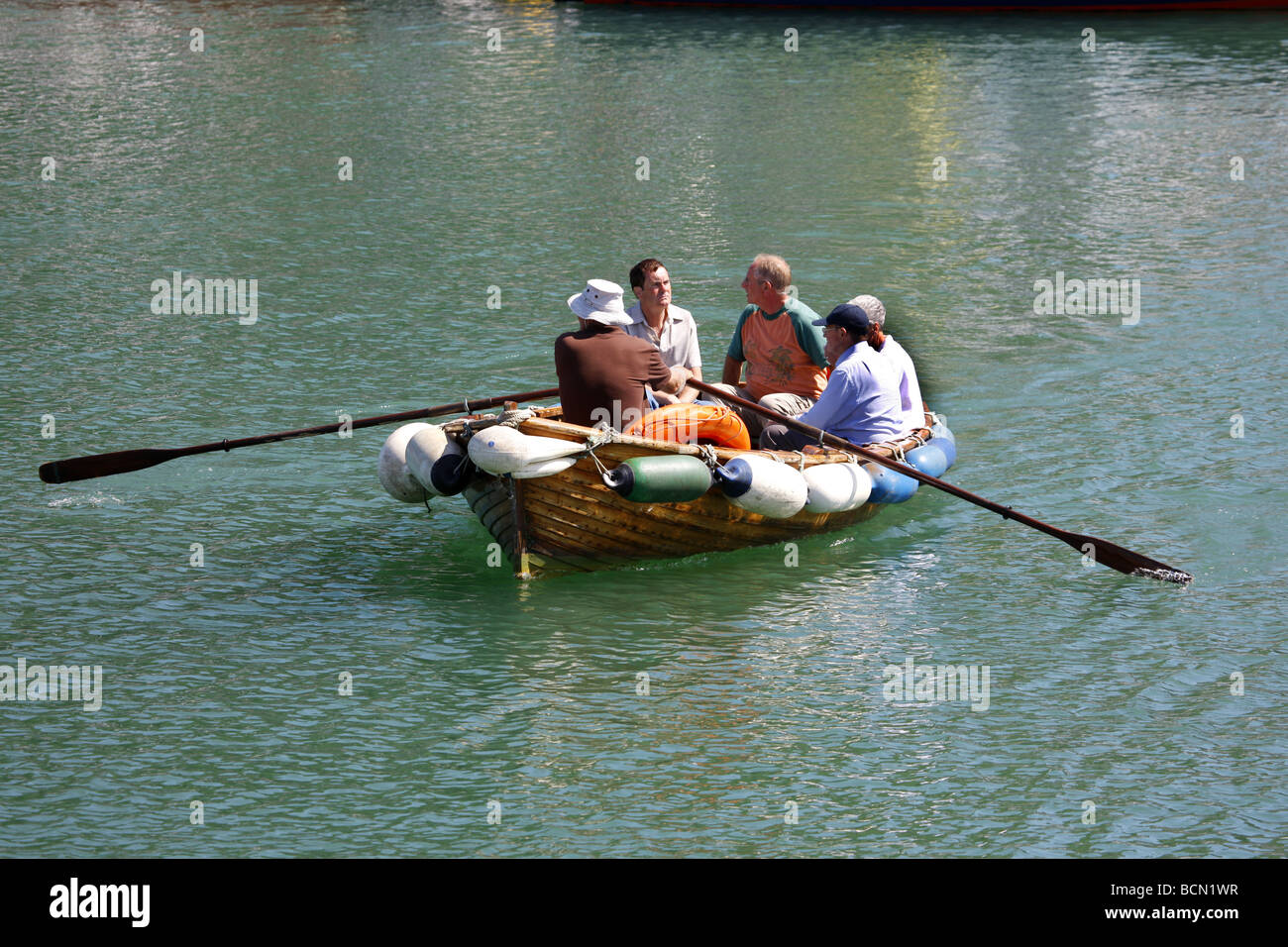 Five people in a rowing boat Stock Photo - Alamy
