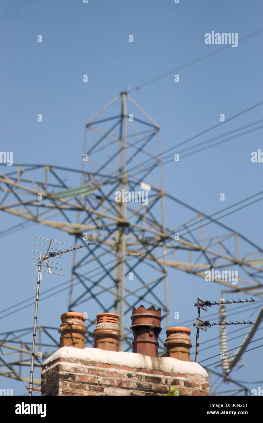 Electricity pylon and house chimney Stock Photo - Alamy