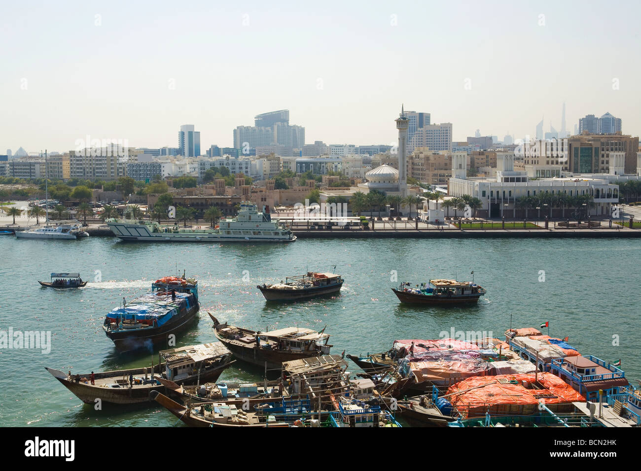 Dhow's arriving into Dubai creek cargo port against Bastakiya skyline ...