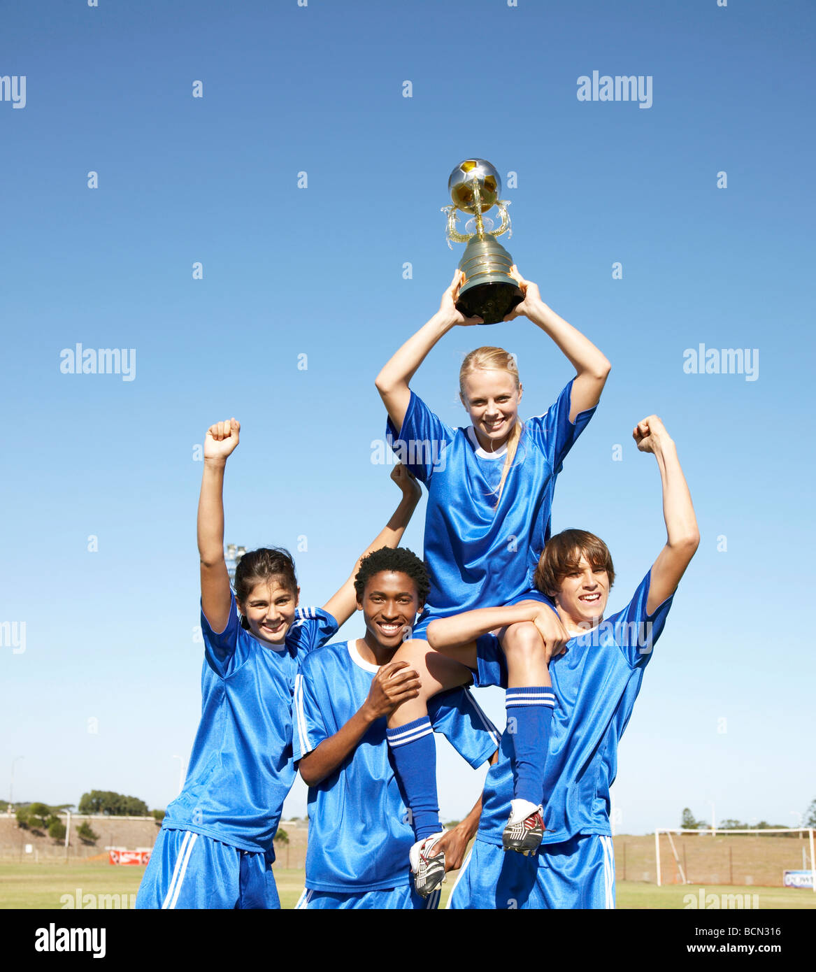 Soccer team holding up winning trophy with pride Stock Photo - Alamy