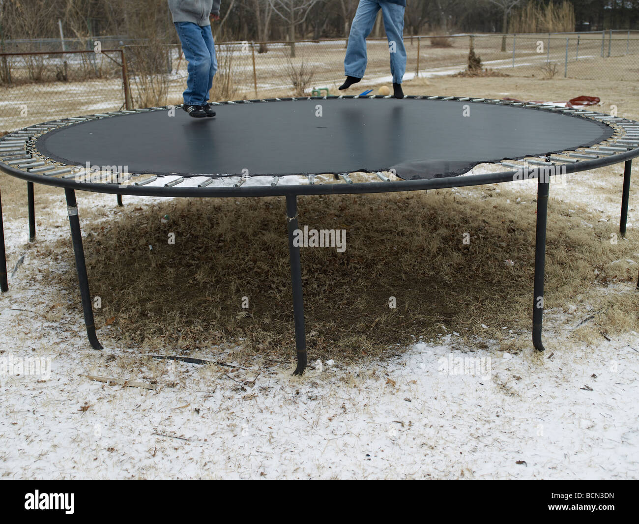 Low Section of Two Children Jumping on Trampoline Stock Photo - Alamy