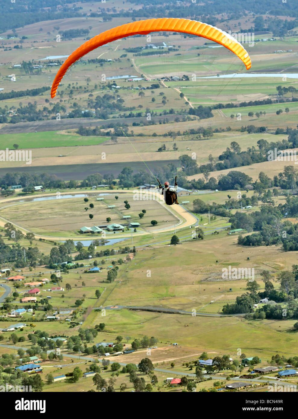 Paragliding with canopy fully inflated and pilot navigating to landing ...