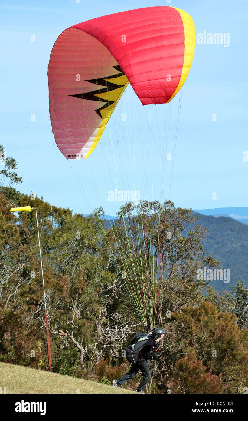 Paragliding with canopy fully inflated and pilot navigating to landing ...