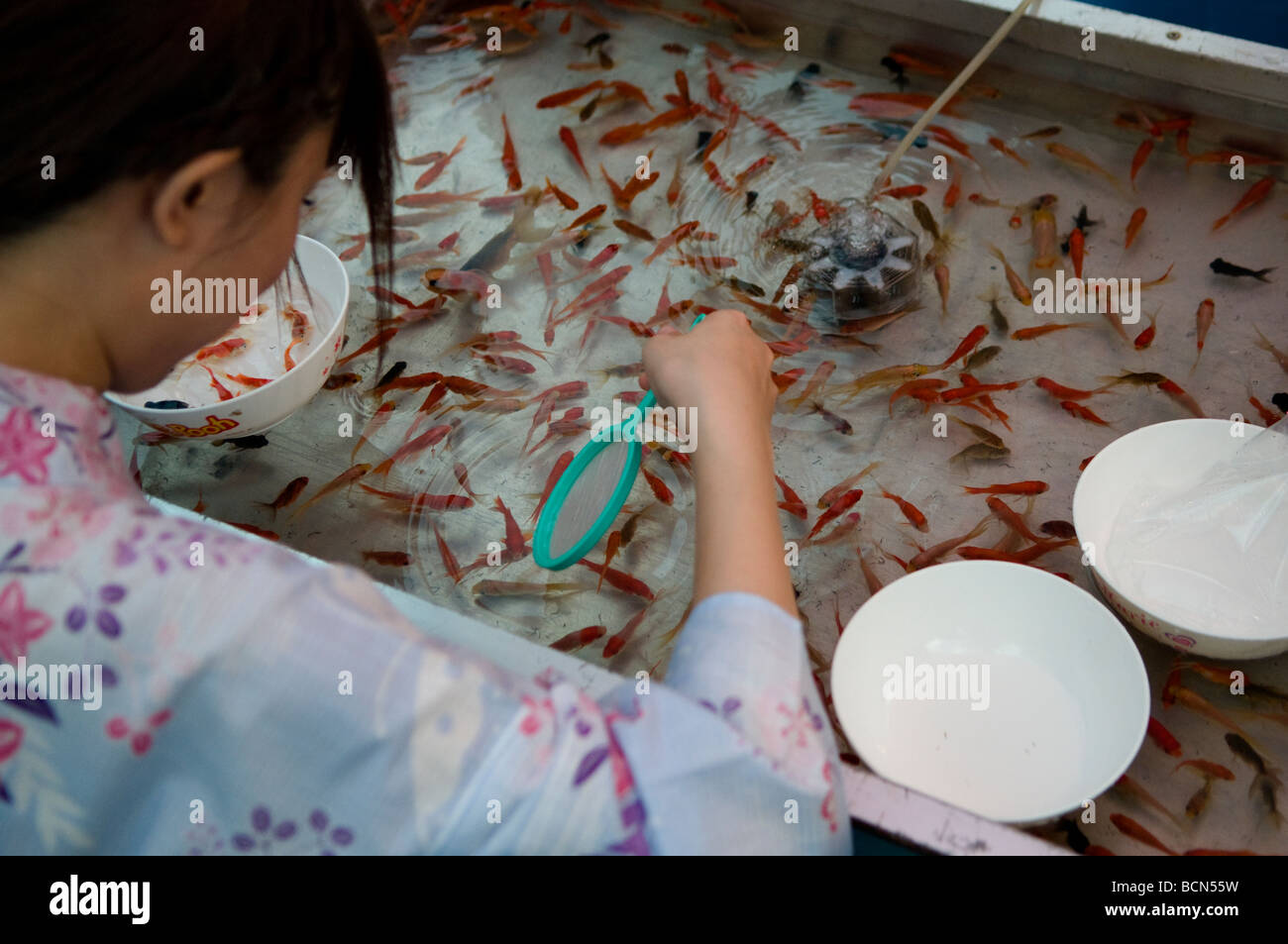 Japanese children scooping goldfishes using a tiny paper net called ...