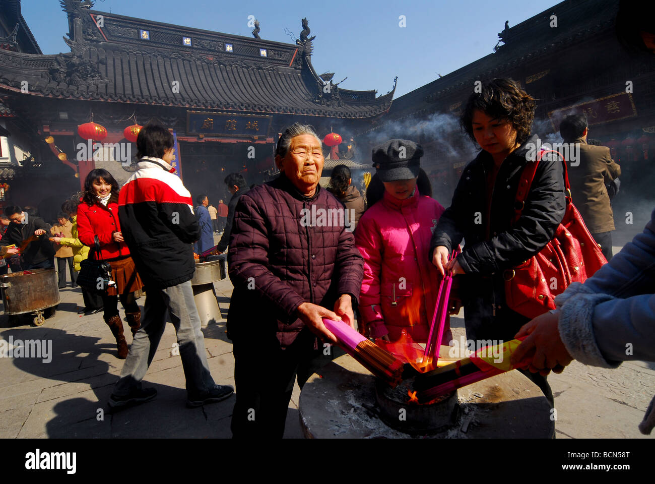 People burning incense to pray to deity in City God Temple, Shanghai ...