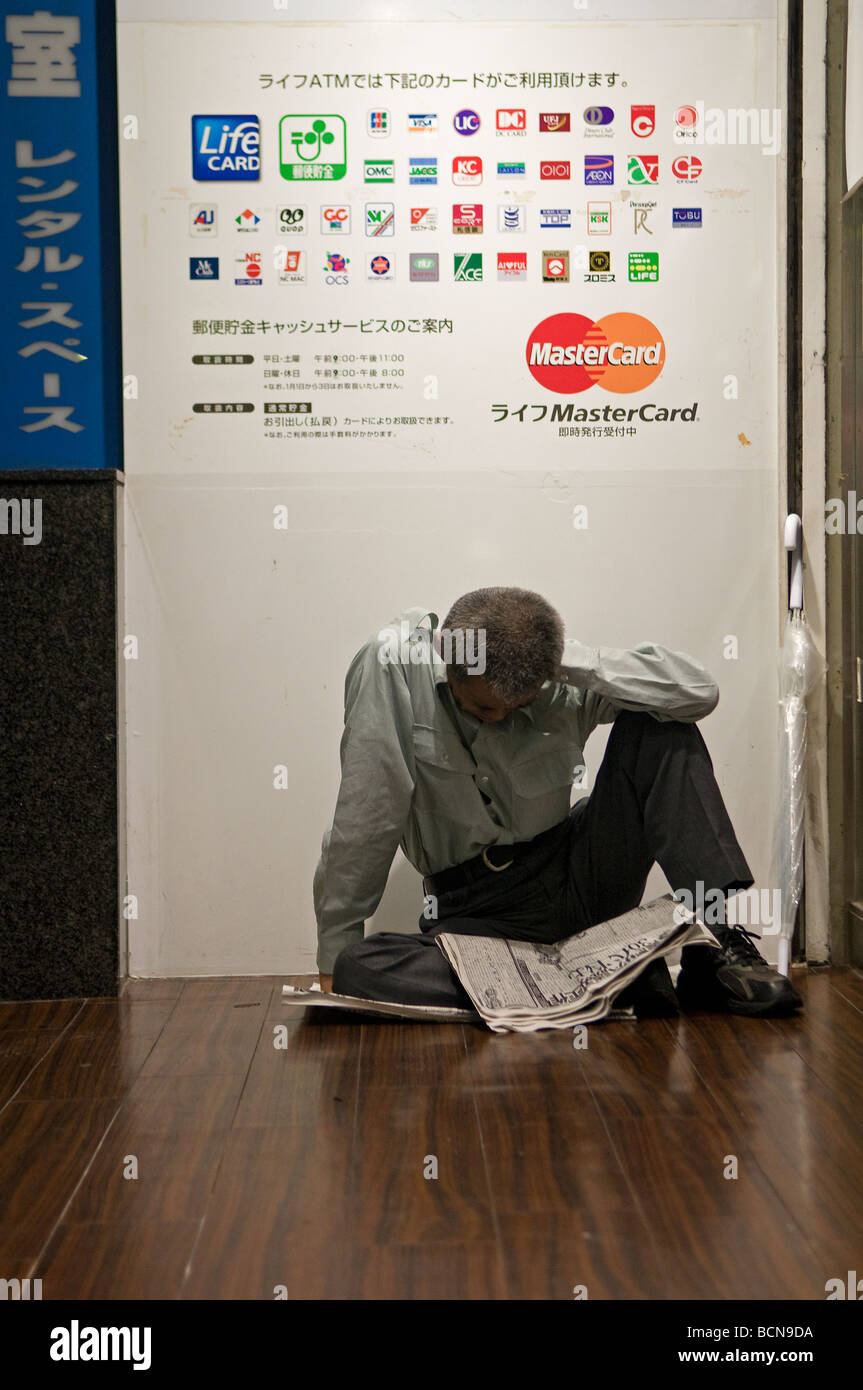 A homeless reading a newspaper in Shibuya commercial district Tokyo ...